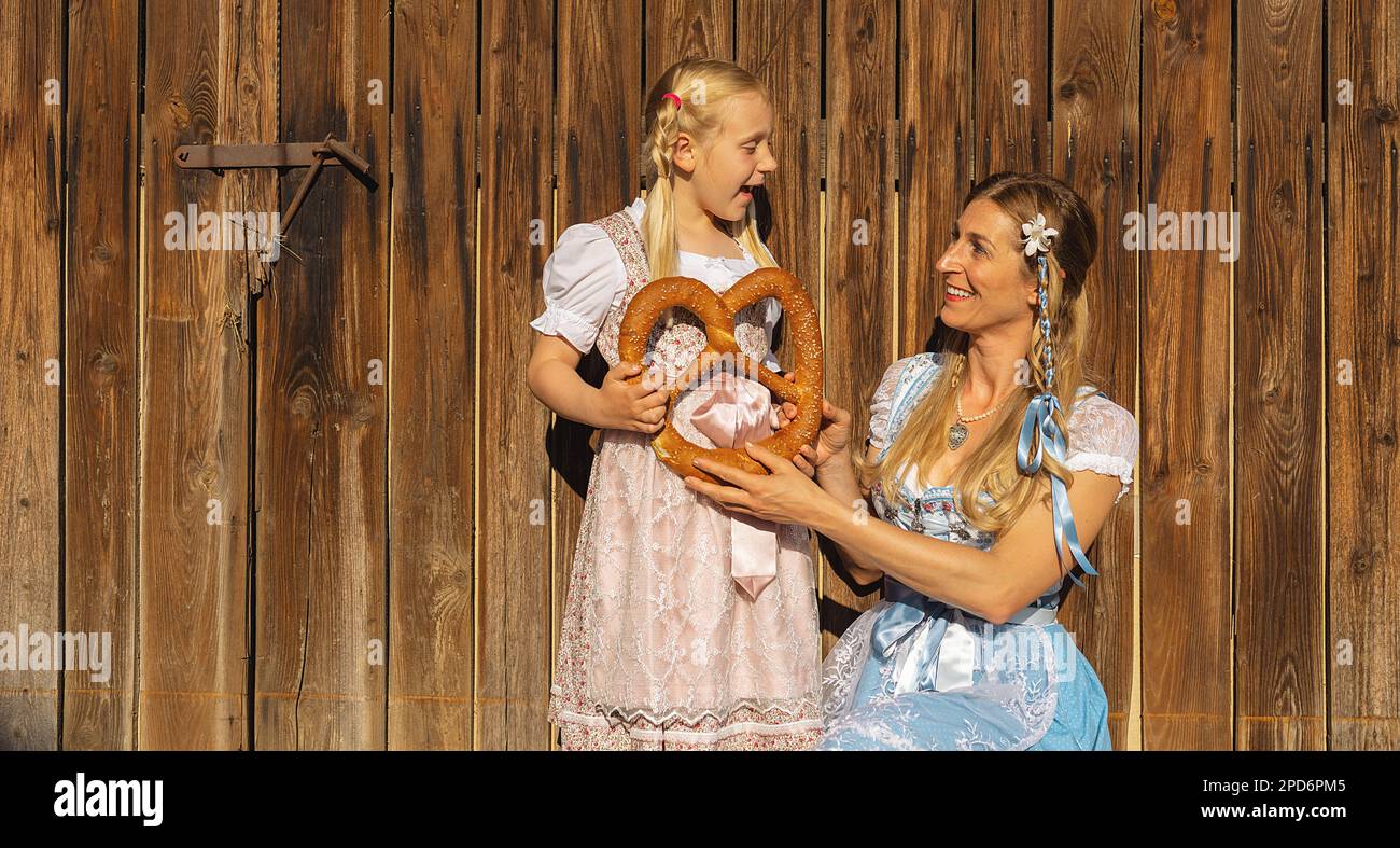 Mother and daughter holding milk cans in traditional Bavarian Tracht at ...
