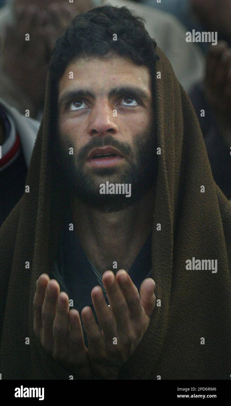 A Kashmiri Muslim prays as head priest, unseen, displays a relic of ...
