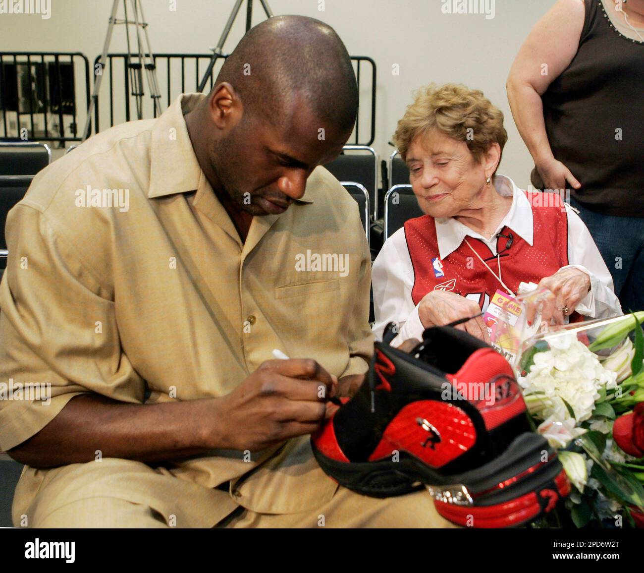 Miami Heat's Shaquille O'Neal, left, autographs his tennis shoe as ...