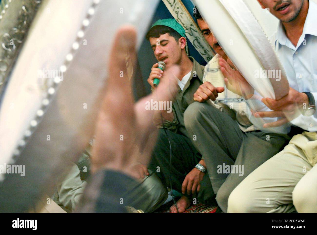 Iraqi men beat traditional drums as a singer performs religious songs ...