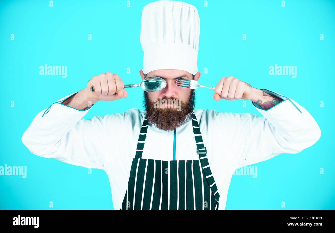 Time to try taste. Chef serious strict face hold spoon and fork. Man ...