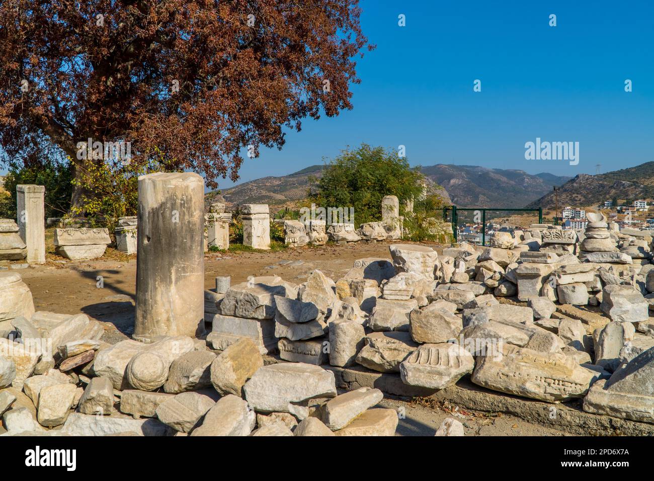 Ancient ruins with a pile of large rocks & old town in the background ...