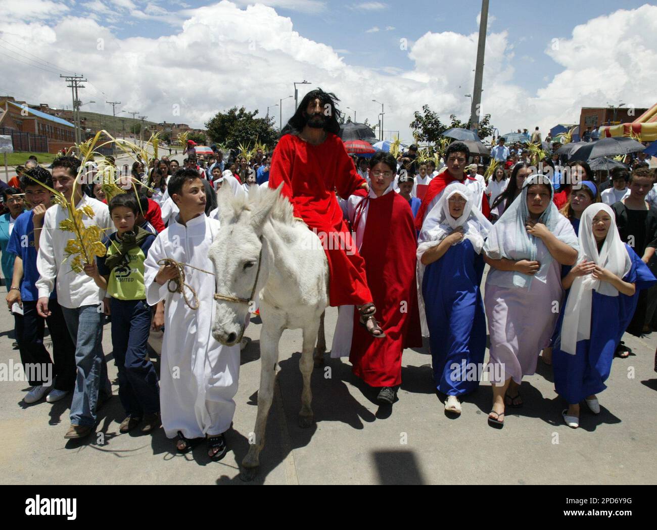 Christians representing Jesus' arrival into Jerusalem hold palm leaves ...