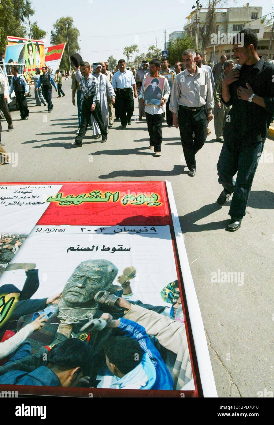 Iraqis preparing for a demonstration look at a poster showing the ...