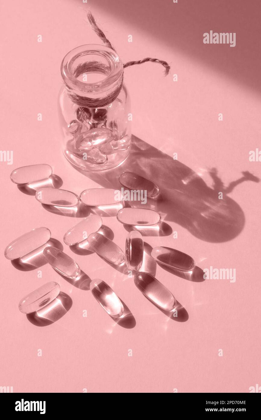 Pills and glass pill bottle on yellow background. Big golden tablets ...