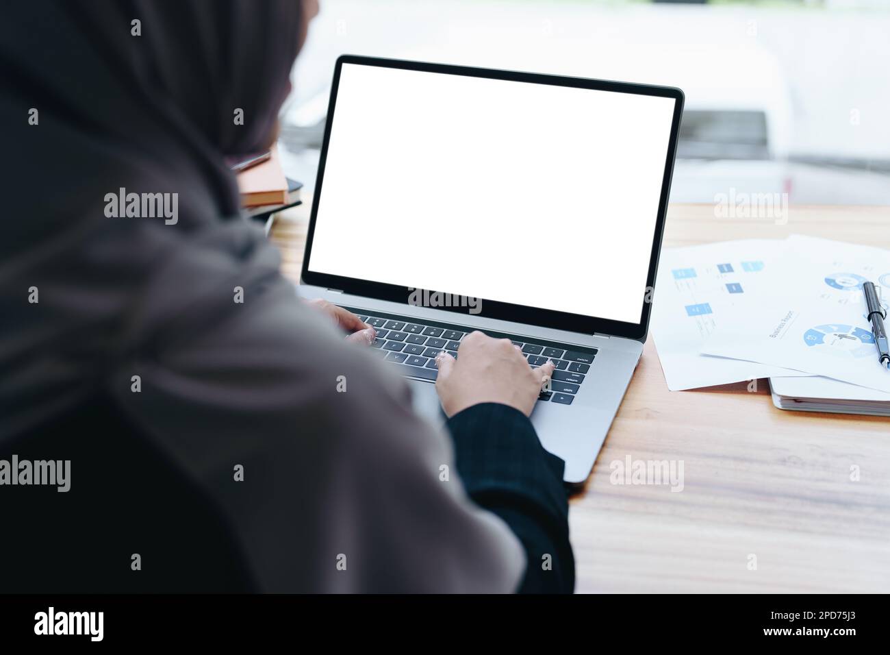 A beautiful Muslim woman uses a white computer screen ready to put text ...