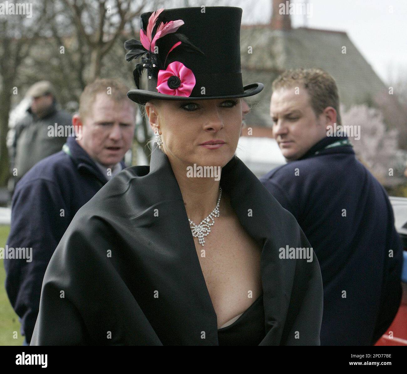 A female race goer catches the eye of two male race goers during the ...