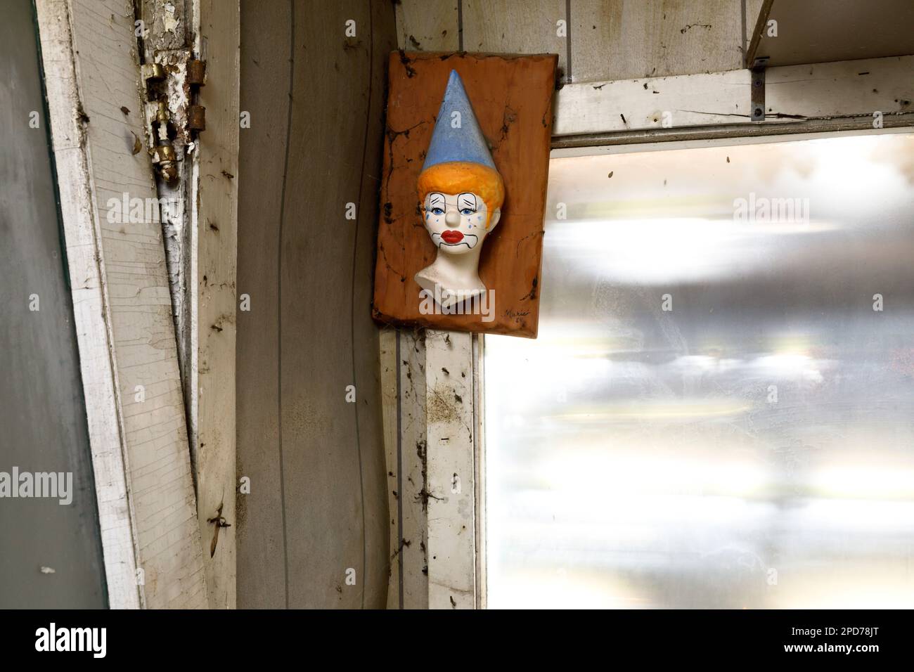 A ceramic female clown hanging on a wall Stock Photo - Alamy