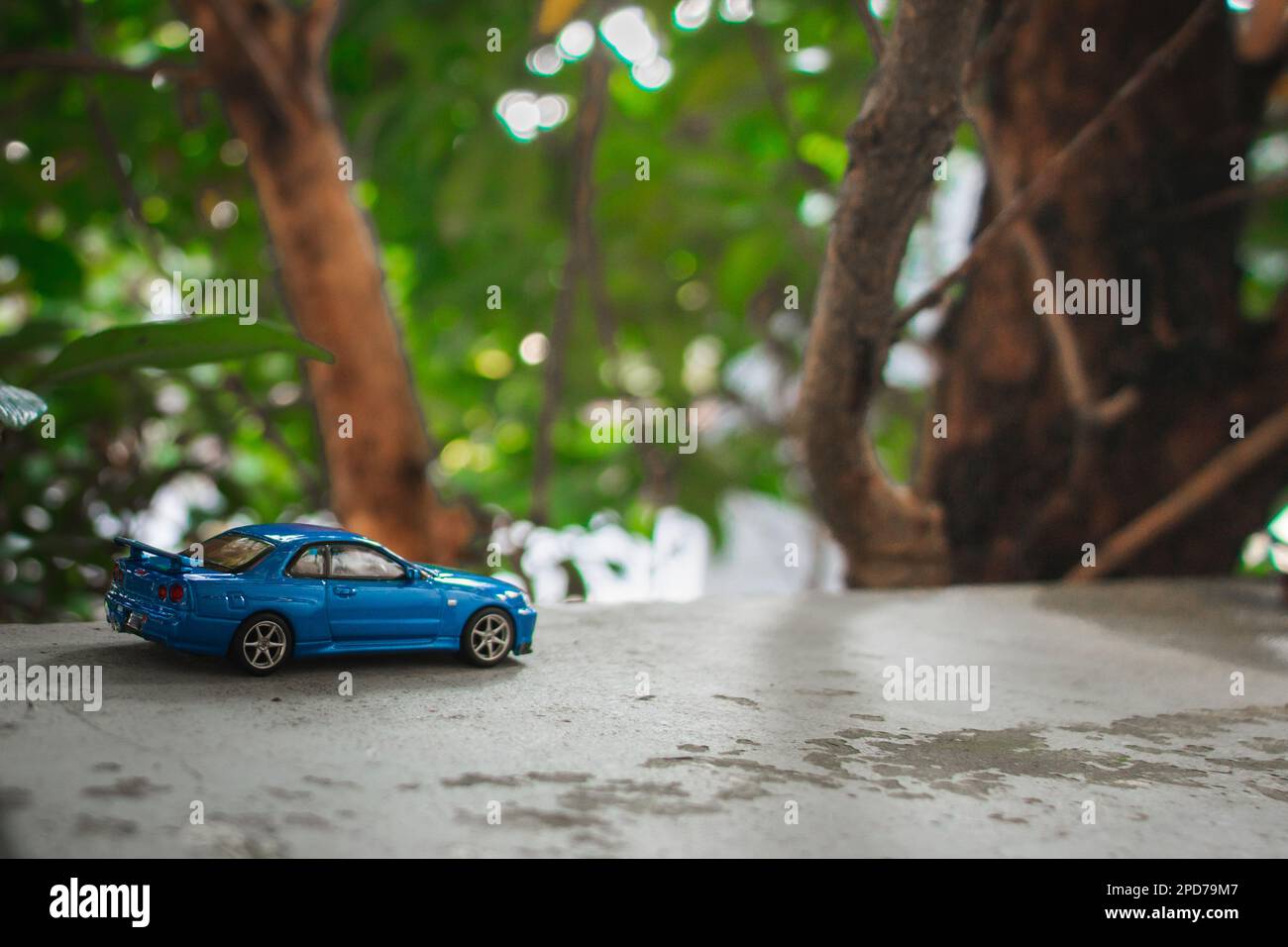 Concept for nature adventure. After some edits, a photo of blue toy car ...