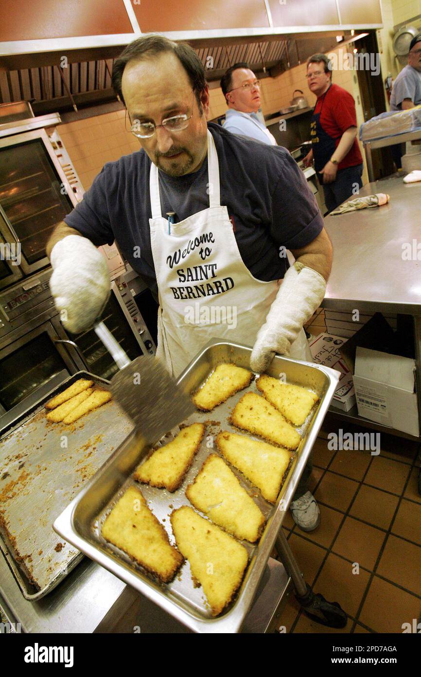 Phil Cillo prepares baked fish as Ed Kitchen, center rear, and Mike ...