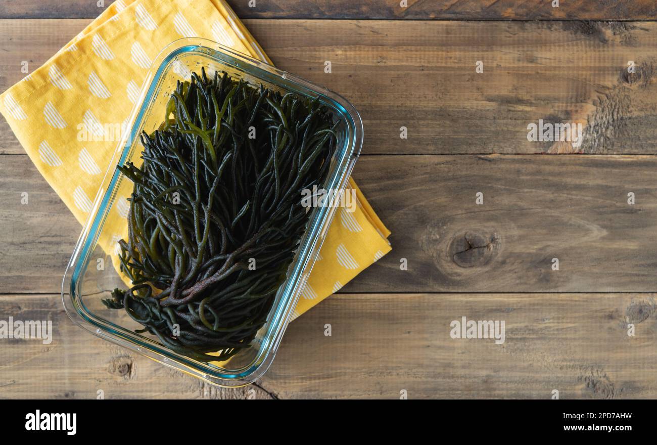 Codium fragile. Green algae in glass bowl on wooden background. Copy ...