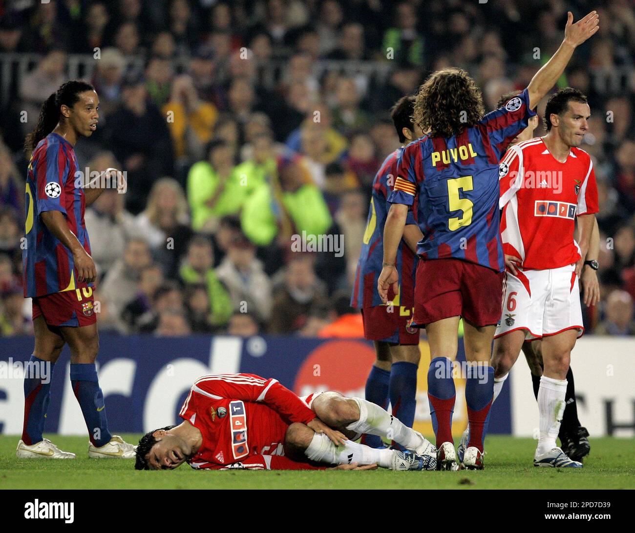 Benfica player Ricardo Rocha lies injured as Barcelona's Ronaldinho and ...