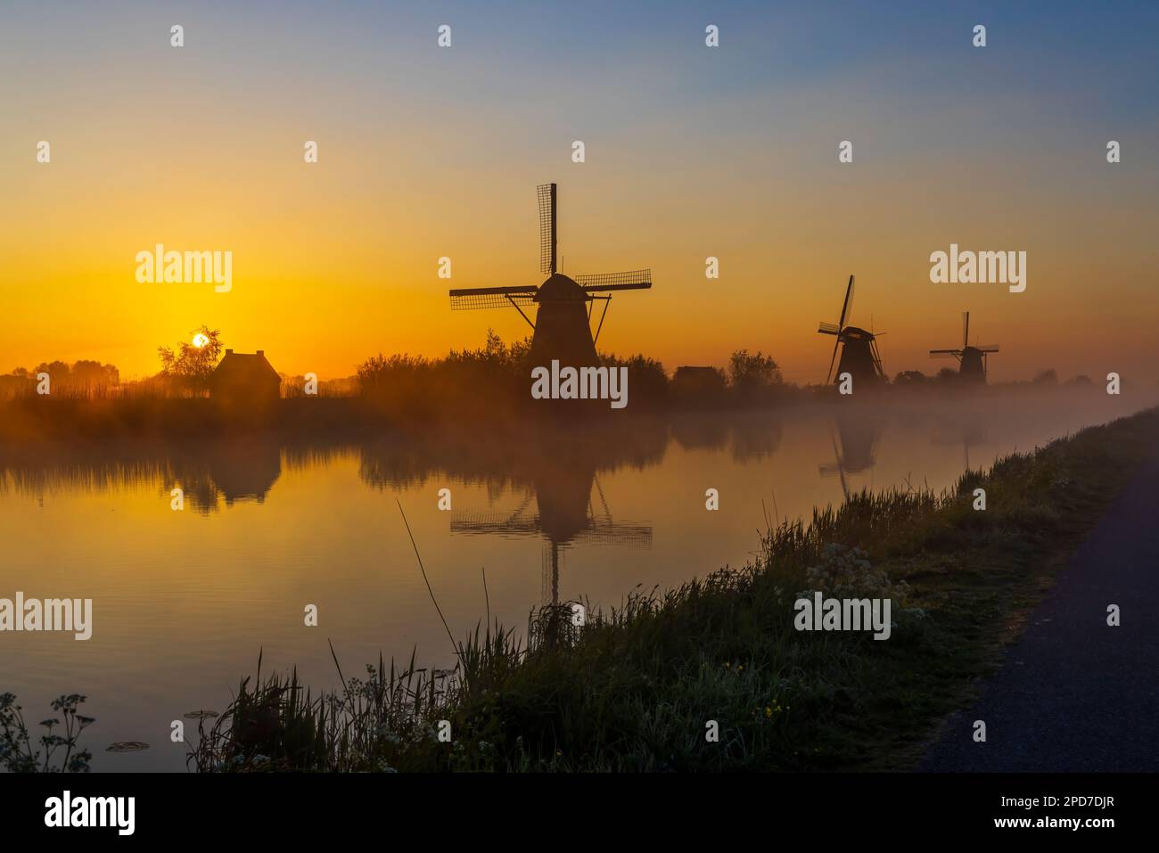 Traditional Dutch windmills with a colourful sky just before sunrise in ...