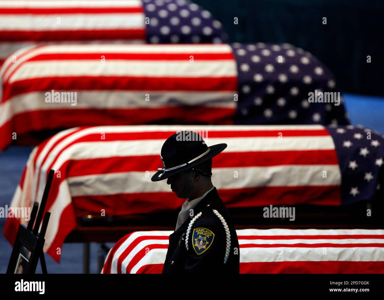 An Oakland Police honor guard stands his post next to the flag-draped ...