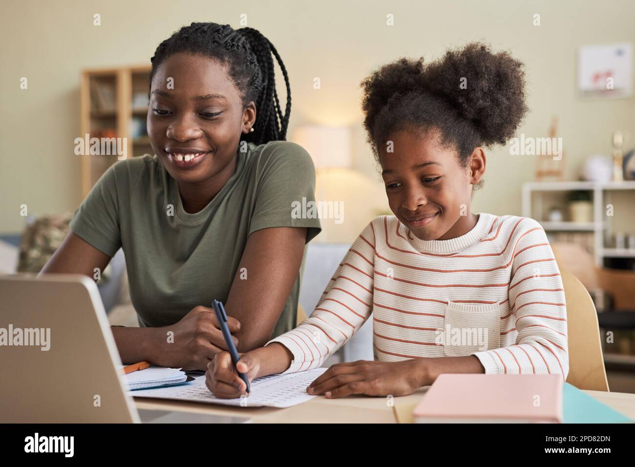 African American little girl studying at home with her mom, they ...