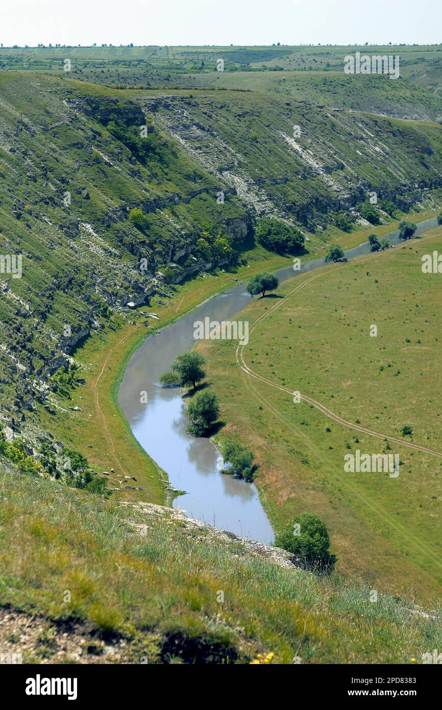 Beautiful natural gorge strewn with hills, grass and trees. At bottom ...
