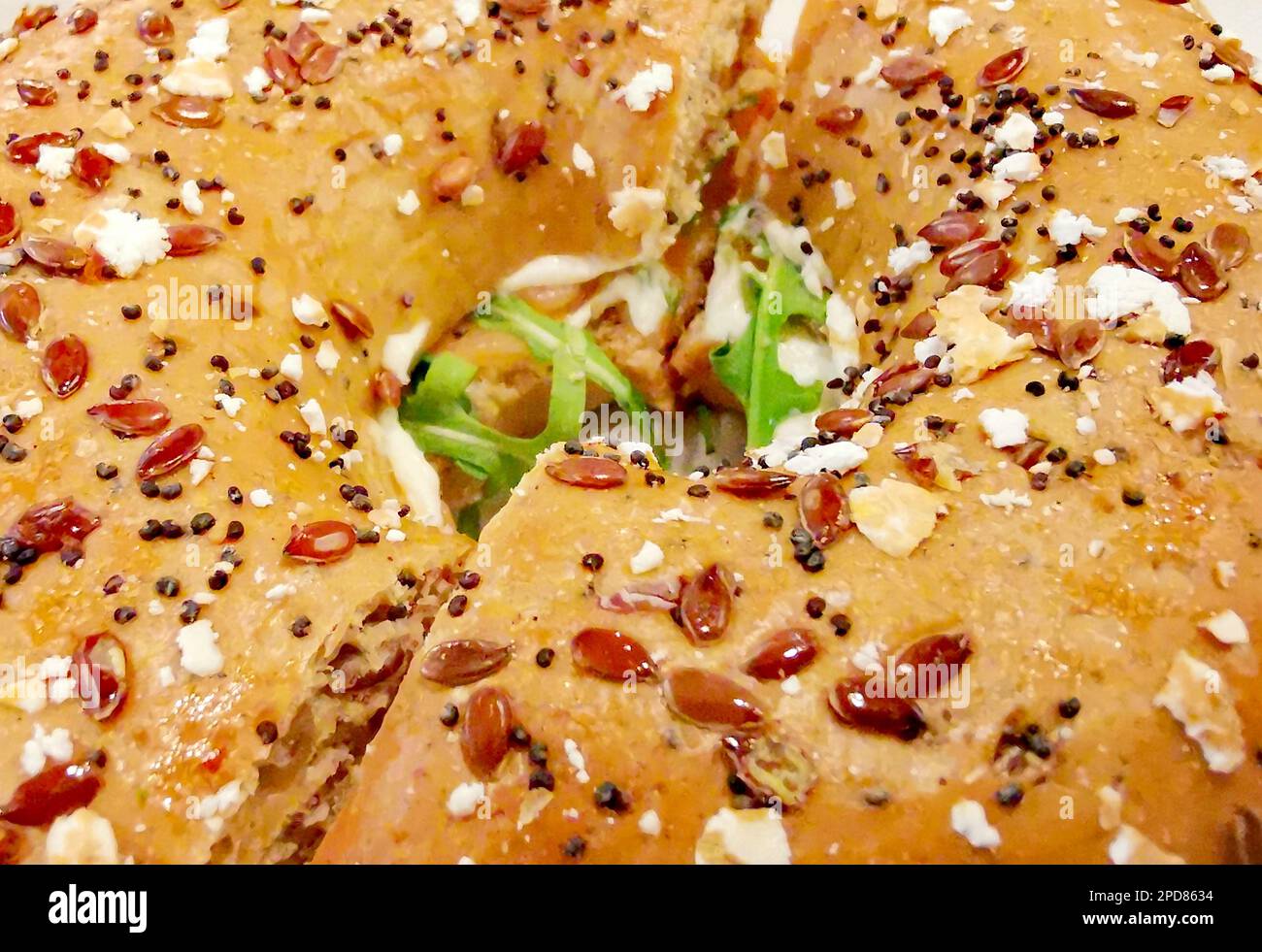 Close up view of brown seeded bagel with green rocket Stock Photo - Alamy