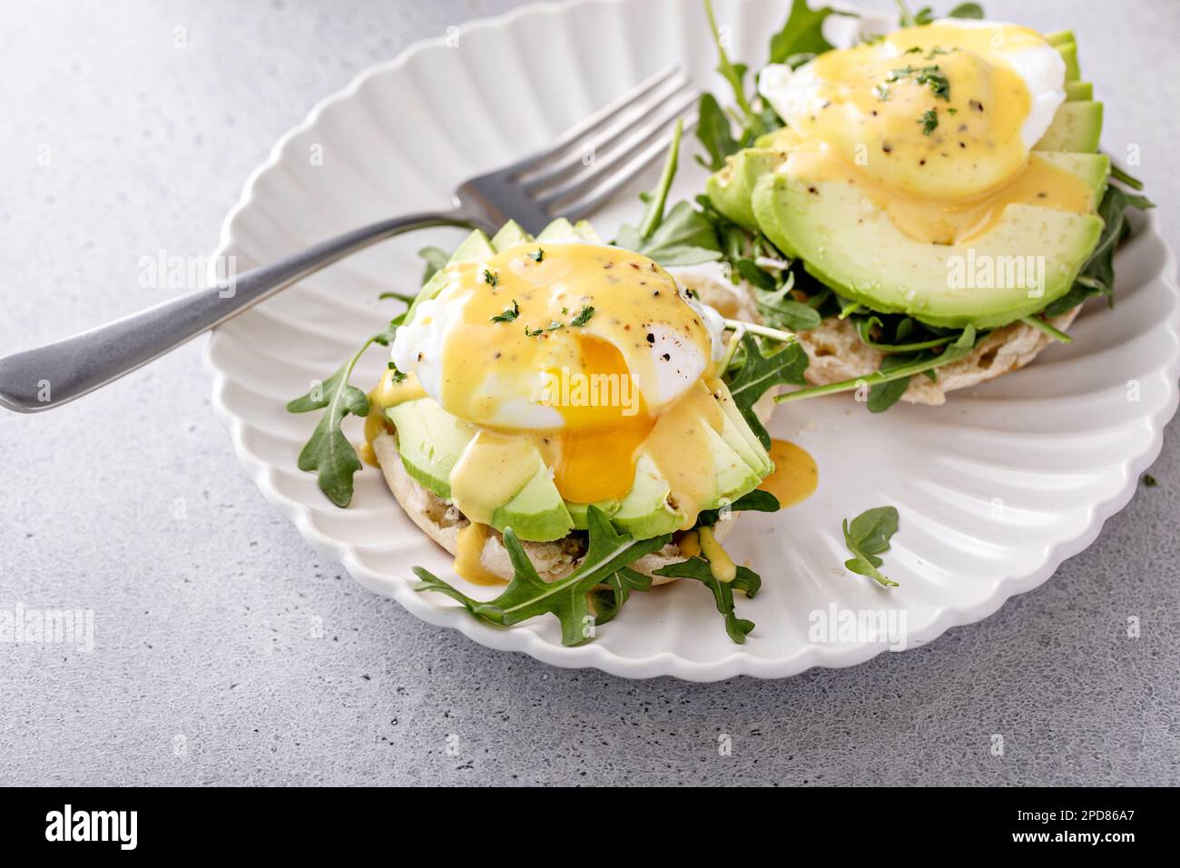 Healthy egg benedict with avocado and arugula Stock Photo - Alamy