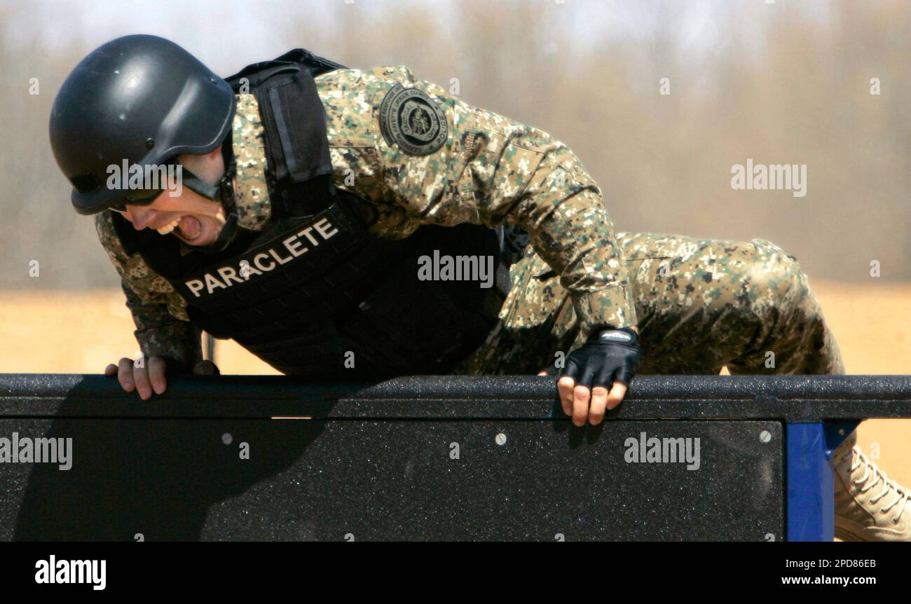 Lexington, Ky., police officer Brian Peterson climbs over a barricade ...