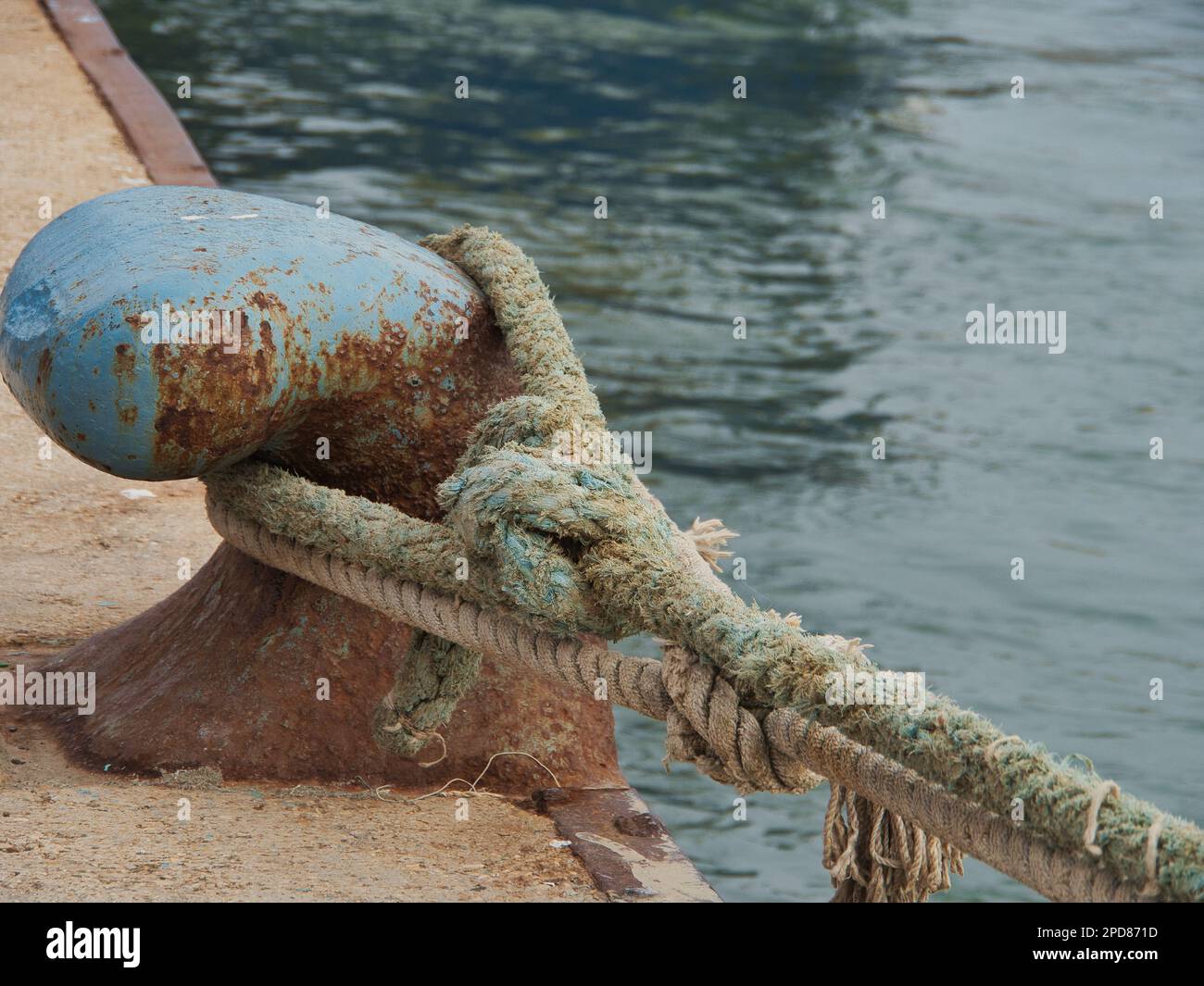 Docking bitte on a wharf. Cast iron terminal with a sailor rope to hook ...