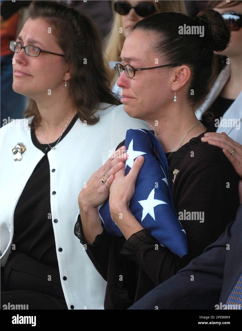 Connie McGrane, widow of Deputy James McGrane Jr., clutches a flag as ...