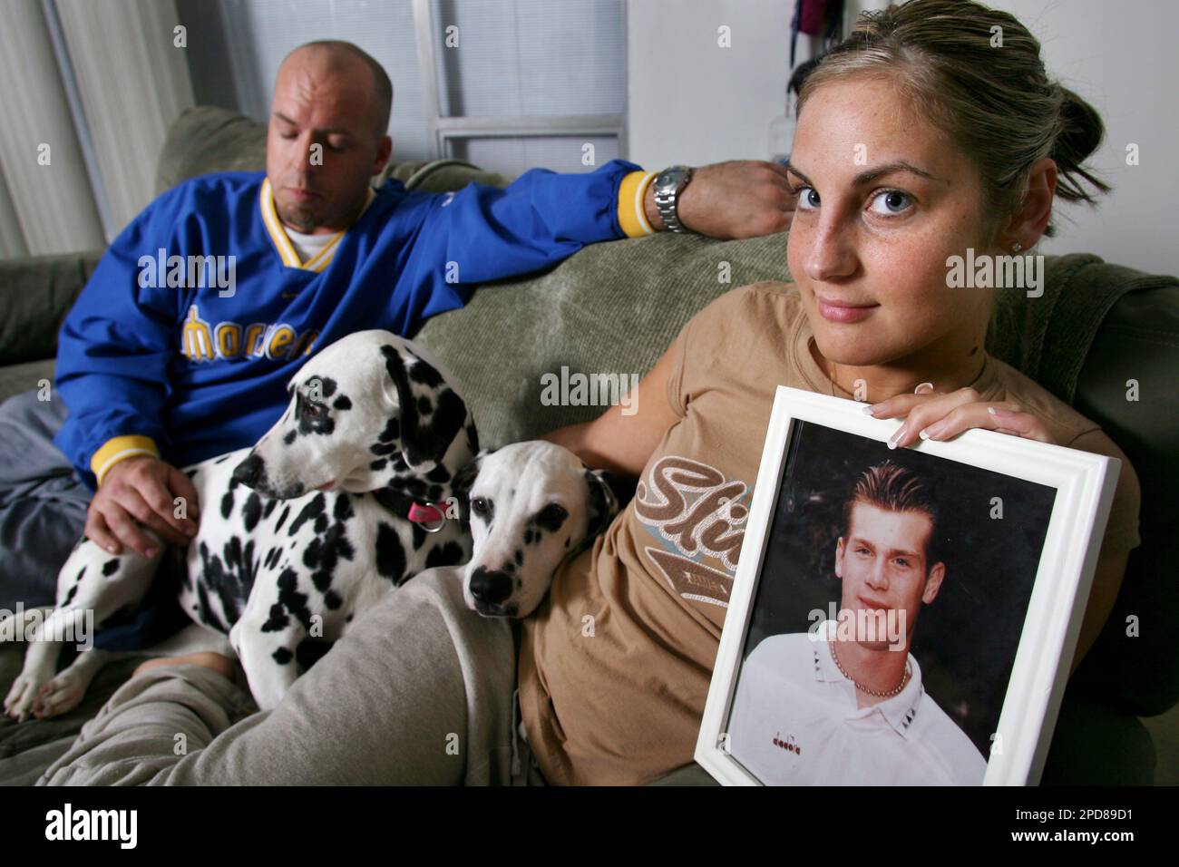 Kirsten Kime holds a photo of her brother Kristopher as she sits with ...