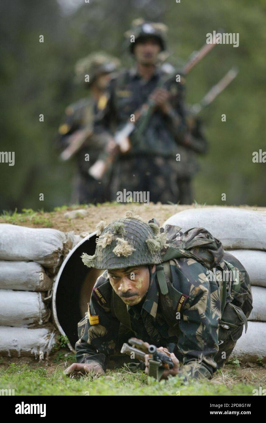 An Indian army soldier crawls through an obstacle during a training ...