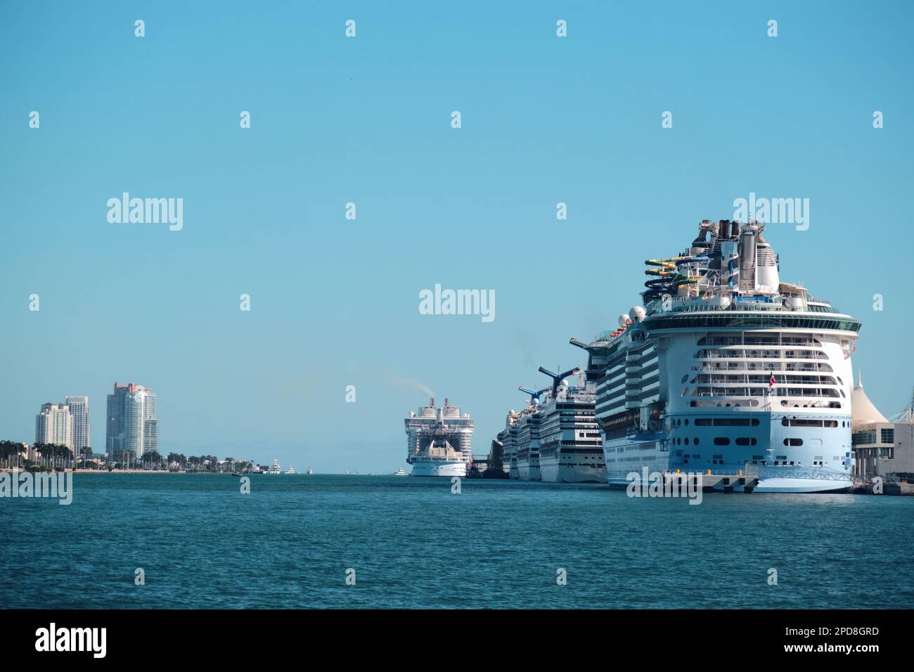 A queue of large cruise ships at the harbor with clear blue sky and a ...