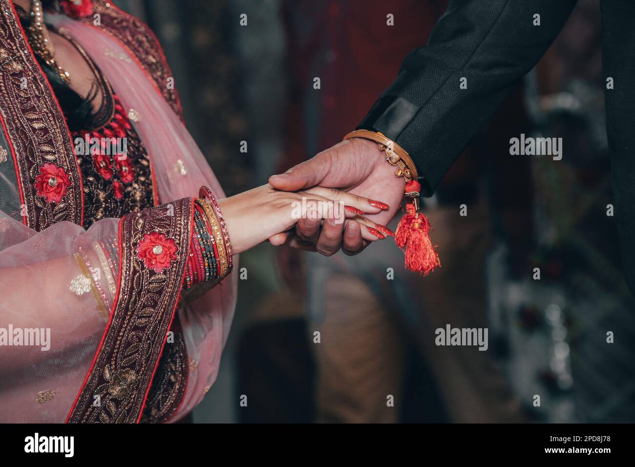 A bride and groom hold hands on their wedding day, the bride wearing a ...