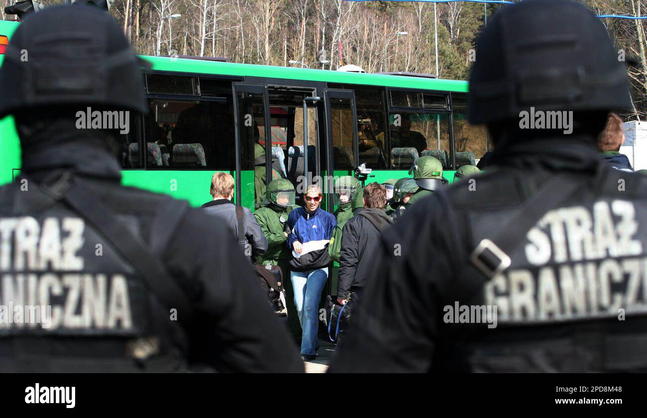 Polish border police, left and right with backs to camera, and their ...