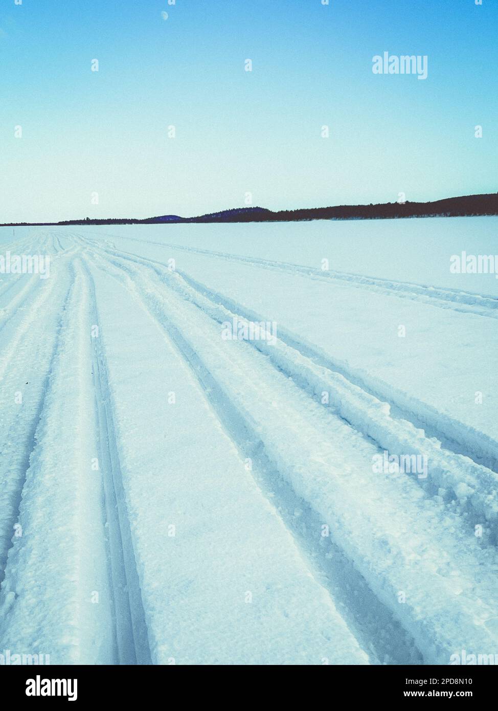 A winter landscape featuring long, parallel lines in the snow ...