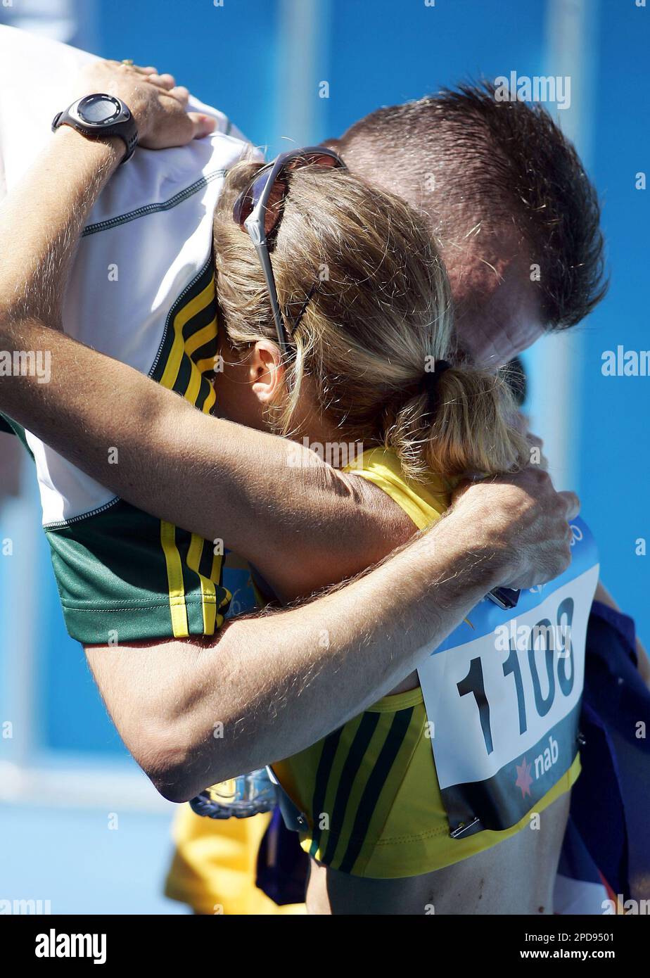 Australia's Kerryn McCann is embraced by her coach Shaun Creighton ...