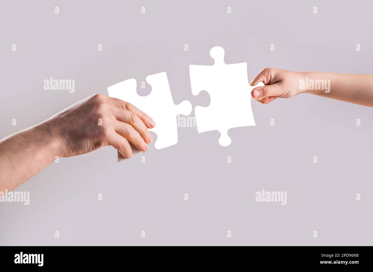 Puzzles. Hand of the child and hand of mother fold puzzle, closeup ...