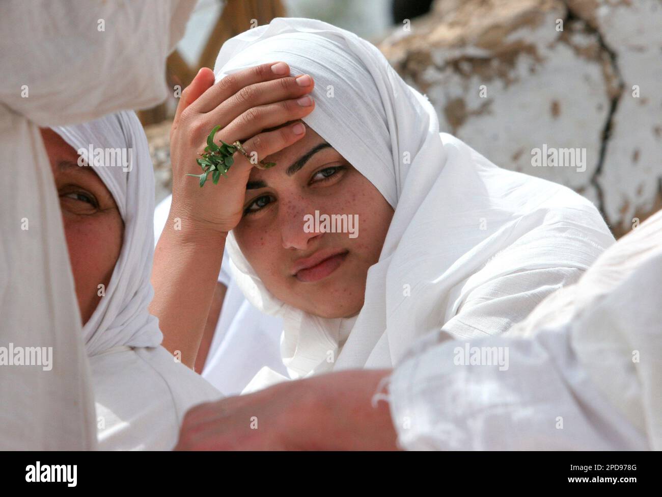 A woman follower of the ancient Sabaean Mandean religious sect sits ...