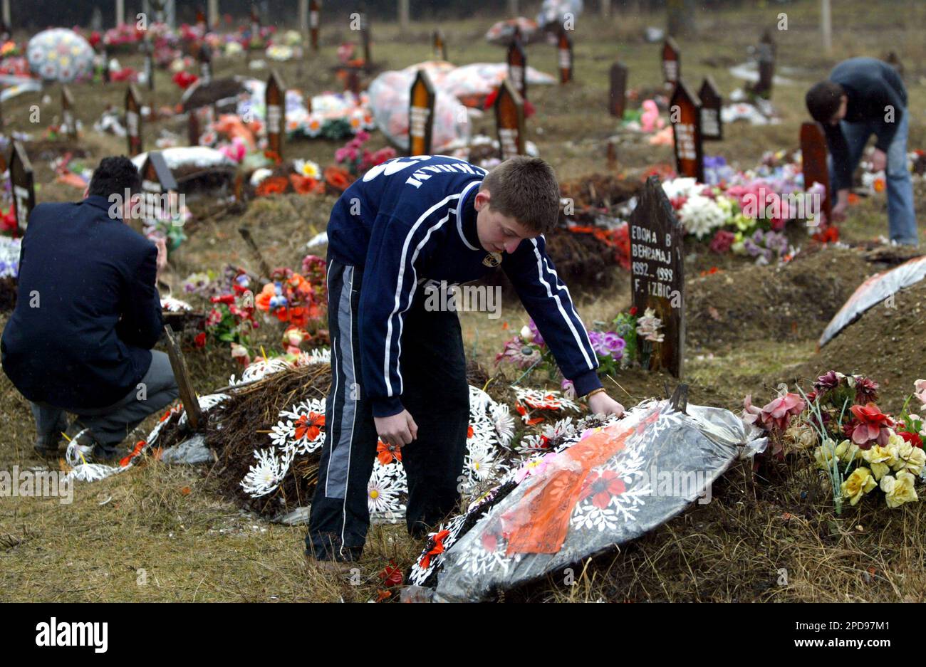 Ethnic Albanian Visar Behrami, 12, looks over the grave of his brother ...