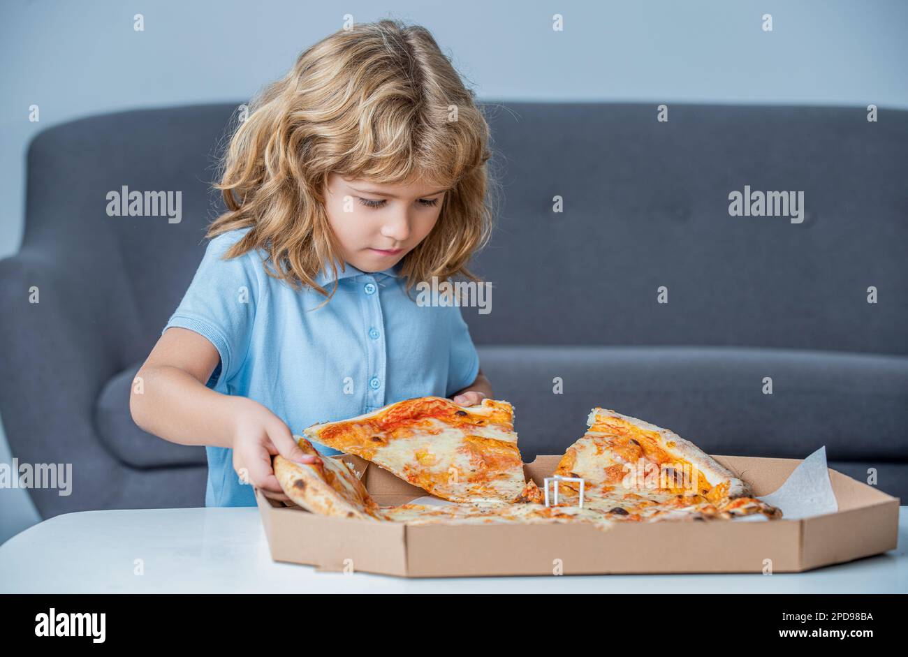Little boy eating pizza. Cute little boy eats pizzas. Happy handsome ...