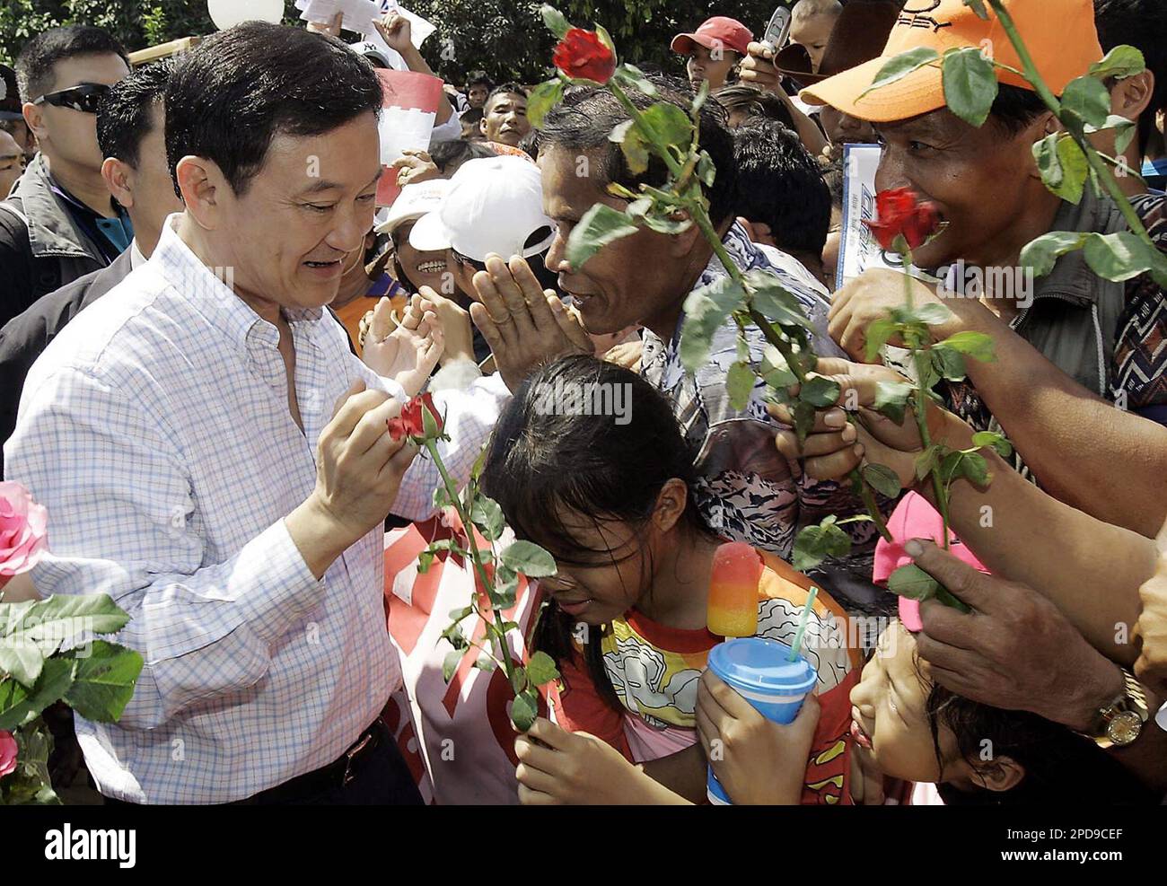 Thai Prime Minister Thaksin Shinawatra, left, is greeted by supporters ...