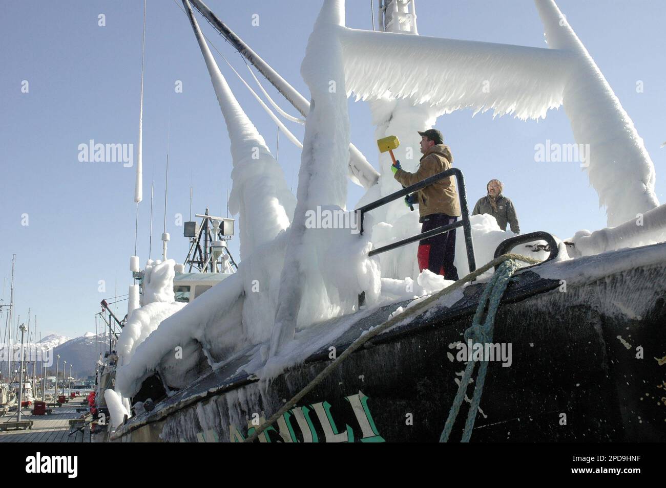 Crewman Brad Wright, left, and Capt. Rod Schneider break ice off the ...