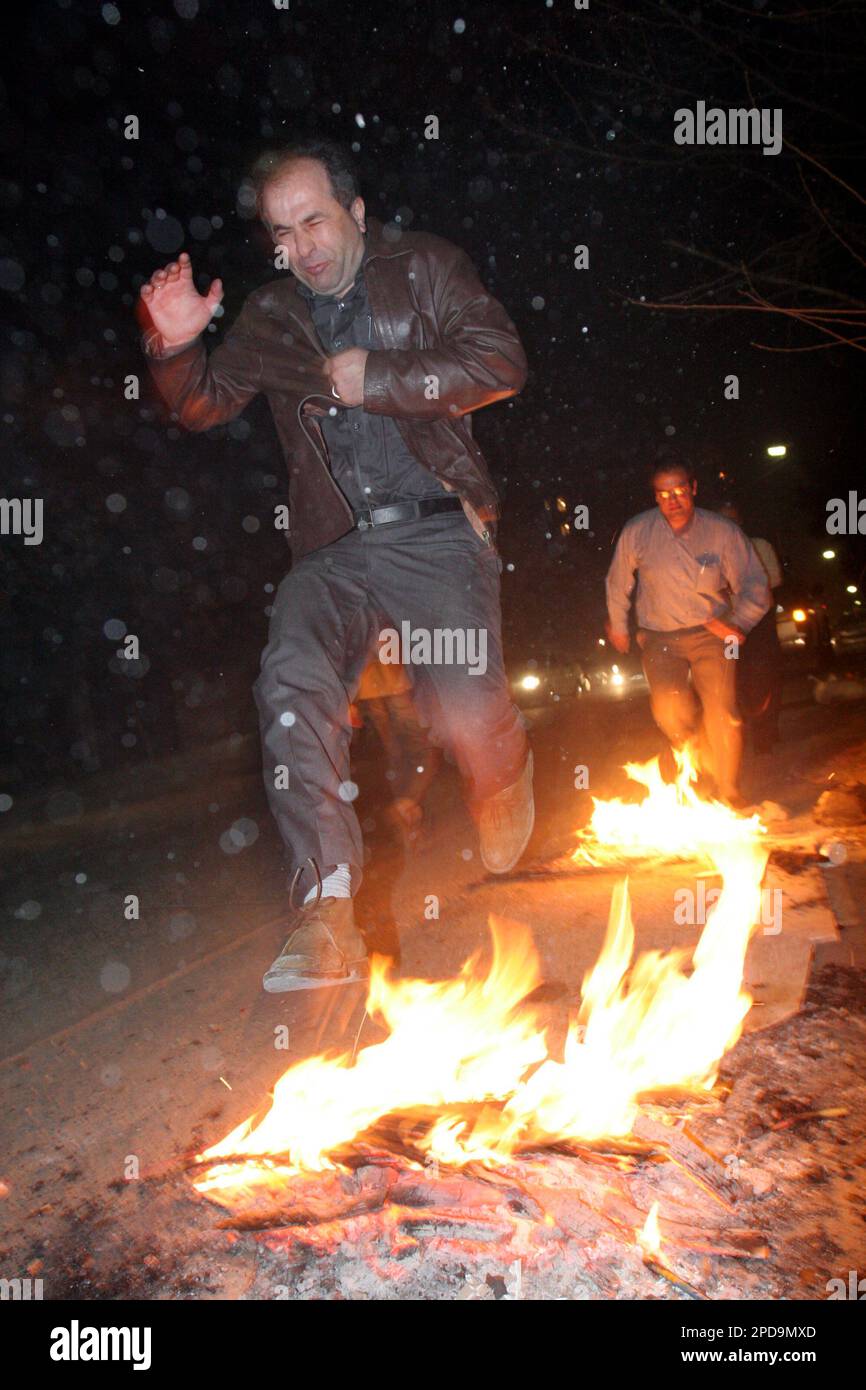 Iranian men jump over bonfires during "Chahar-Shanbe Suri," or ...