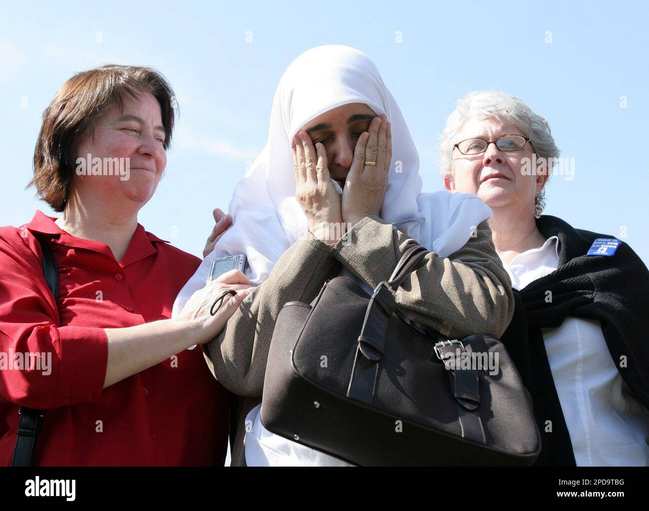 Dr. Rashad Zaydan, center, a pharmacist from Baghdad, Iraq, cries as ...