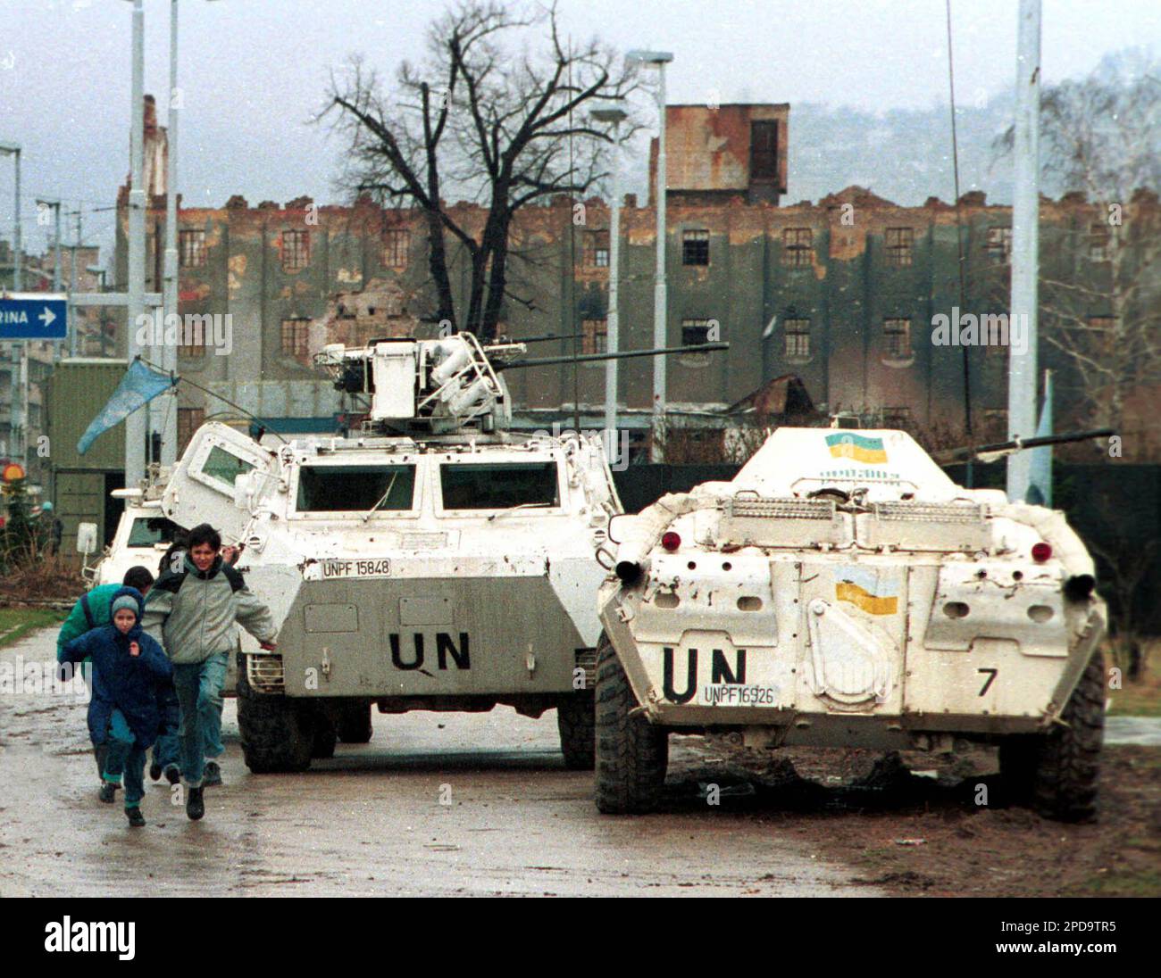 ** FILE ** Sarajevans in 1995 run past United Nations peace force ...