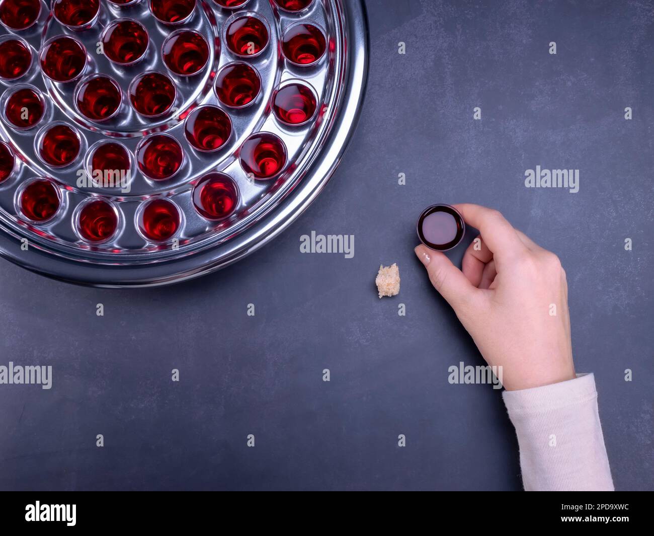 Closeup of young woman taking communion the wine symbol of Jesus Christ ...
