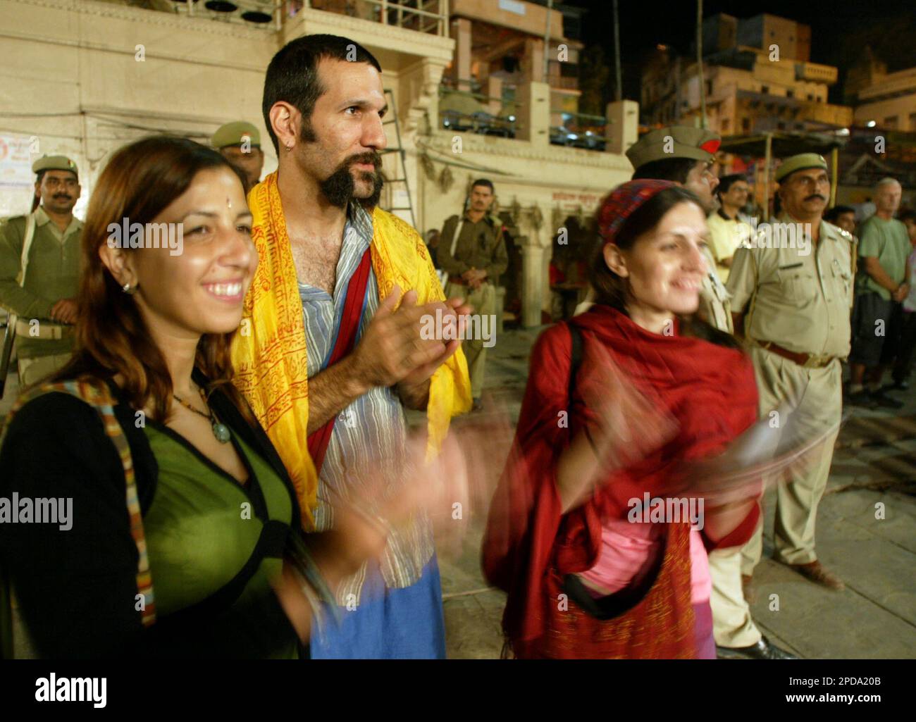 Tourists clap hands as they watch Hindu priests perform daily rituals ...