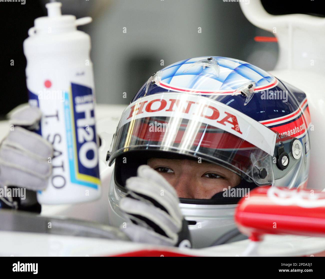 Takuma Sato of Japan sits in the cockpit of his Super Aguri racer ...