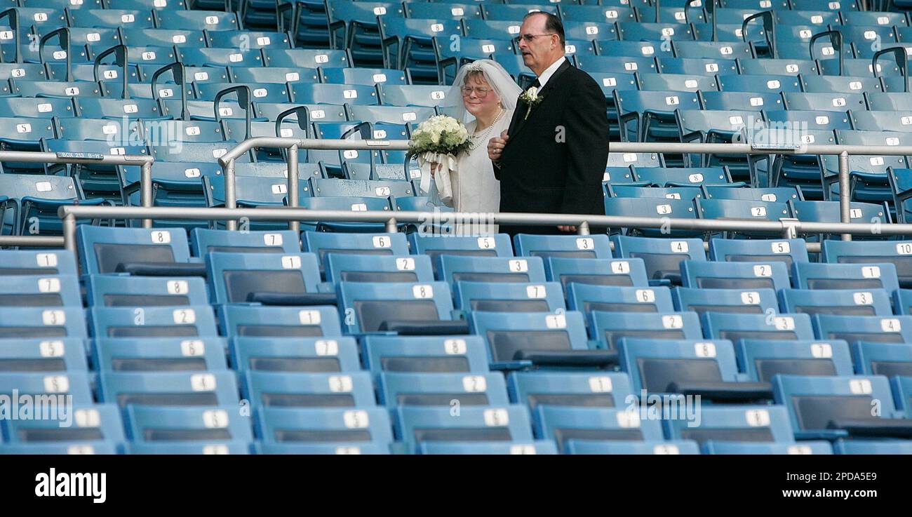 Bride Allison Lucas, left, nee Pheifle, is escorted through the seats ...