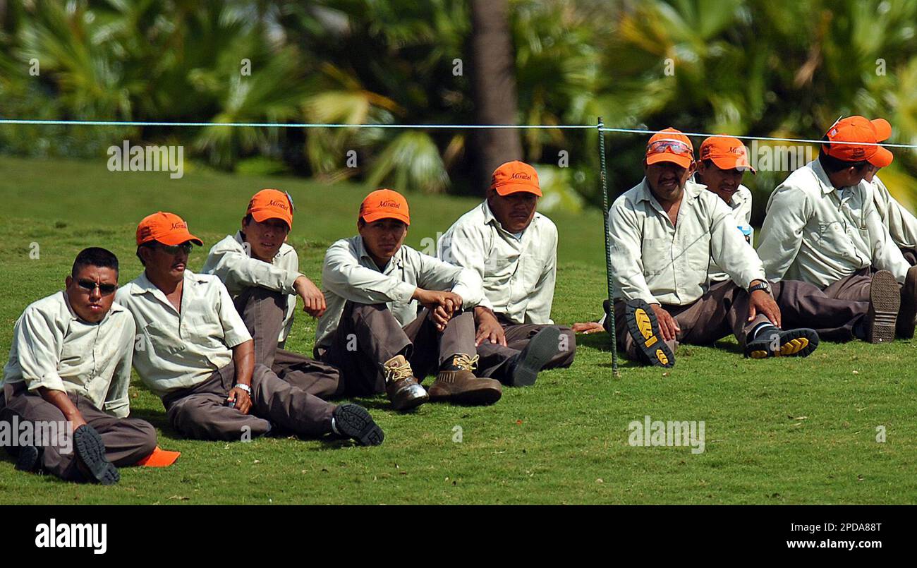 Ground crew members watch from the seventh green during the first round ...