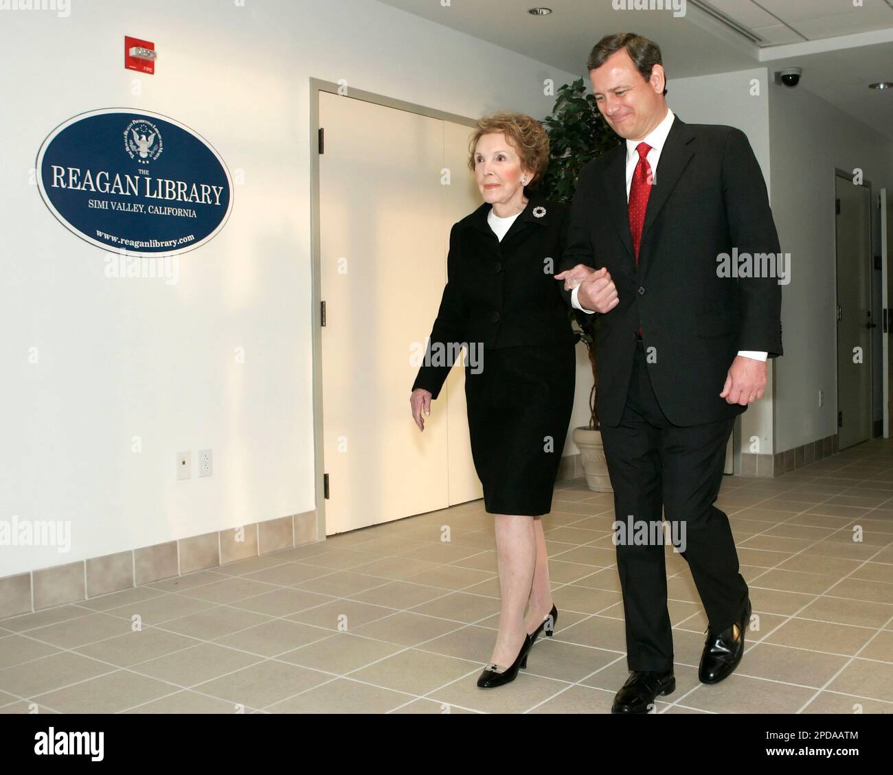 U.S. Supreme Court Chief Justice John Roberts, right, escorts Nancy ...
