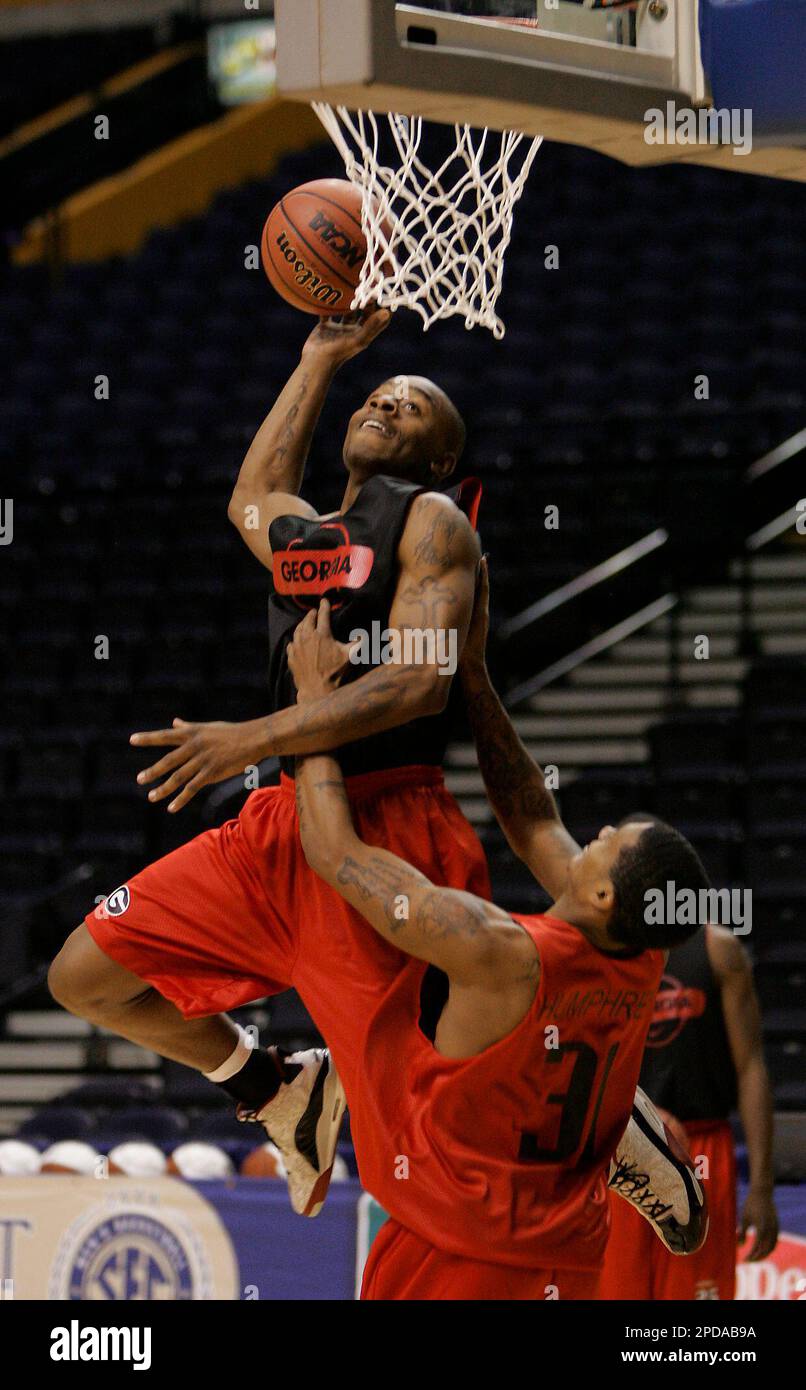 Georgia guard Levi Stukes, top, is hoisted for an assisted dunk by ...