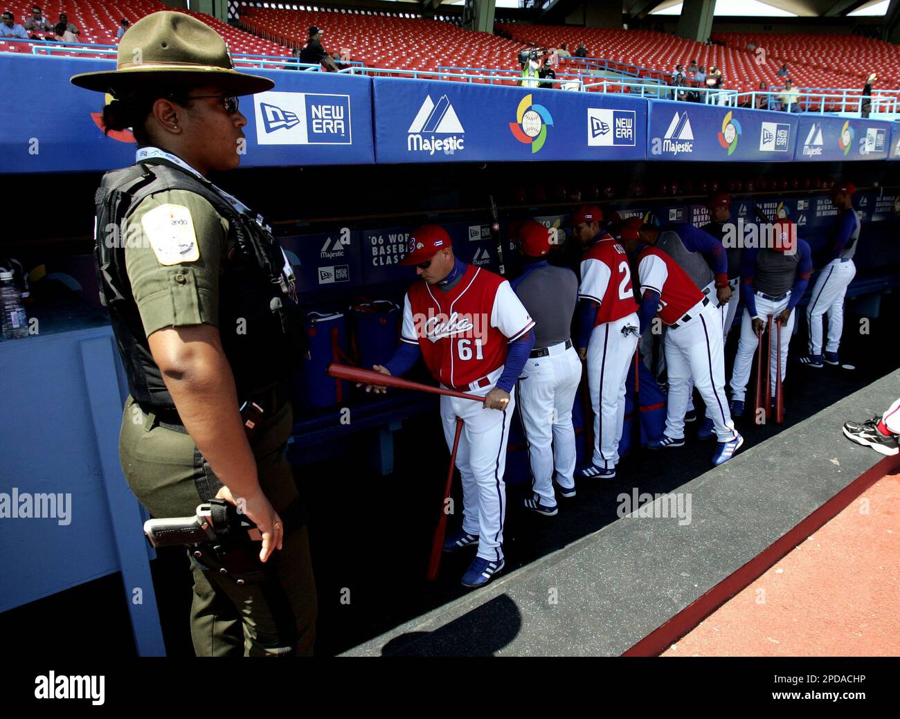 Team Cuba catcher Roger Machado (61) selects a bat in the dugout as a ...