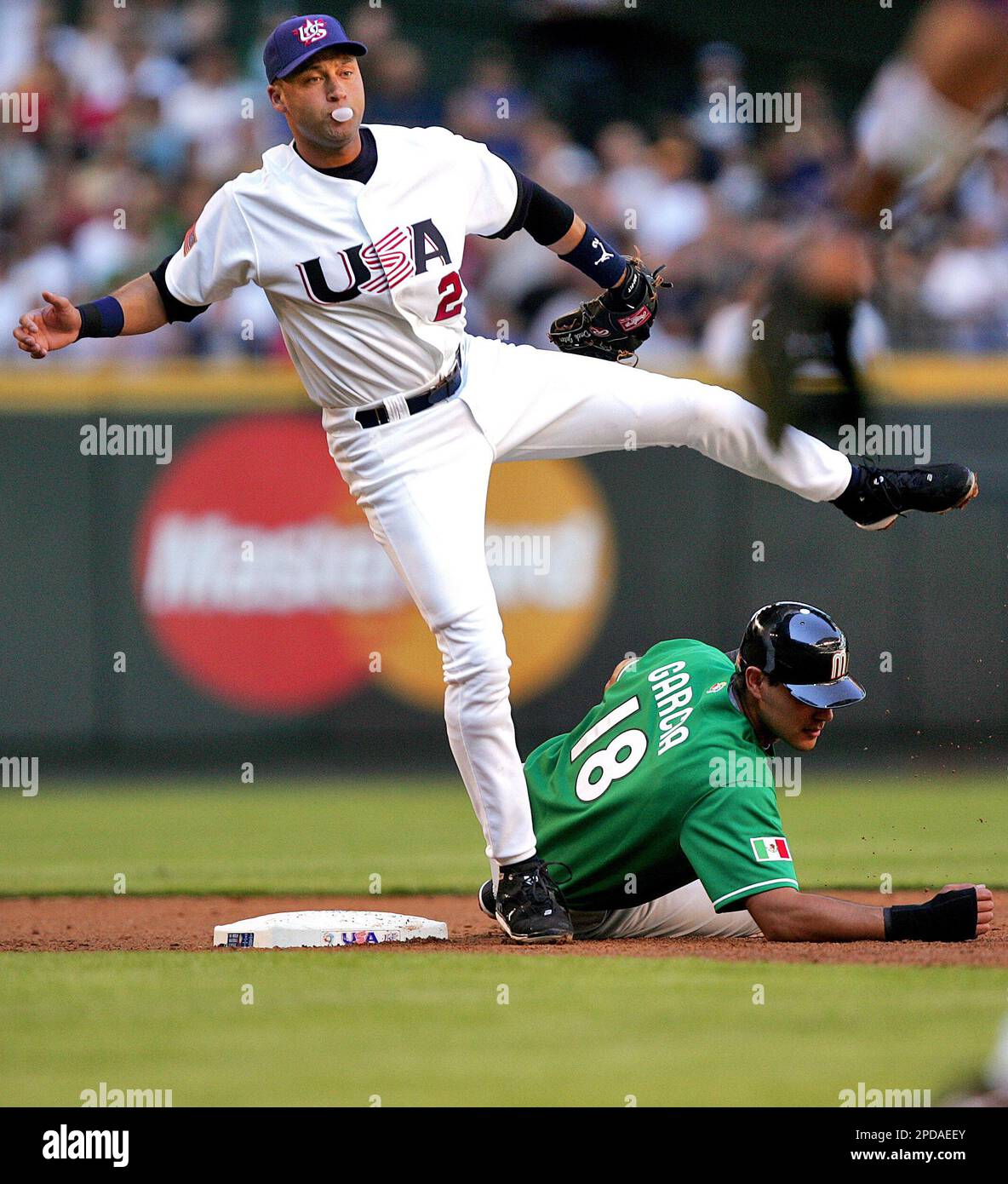 Team USA shortstop Derek Jeter blows a bubble after throwing to first ...